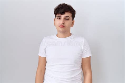 Young Non Binary Man Wearing Casual White T Shirt Relaxed With Serious Expression On Face Stock