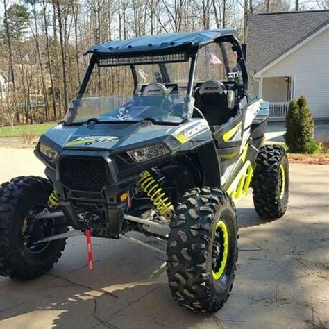 Black And Yellow Polaris Rzr Parked In Front Of House