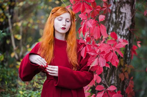 밝은을 바탕에 빨간 코트에 붉은 스트레이트 머리를 가진 여자 창백한 피부와 파란 눈과 손가락 및 빨간 손톱에 반지와 함께 밝은