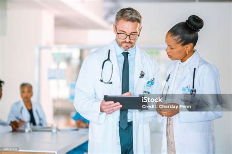 두 명의 의료 전문가와 전문가가 디지털 태블릿을 사용하여 진단 치료 계획 및 절차를 논의하기 위해 협력합니다 병원 또는 클리닉 회의실에서 토론을 하는 의사 의사에 대한 스톡