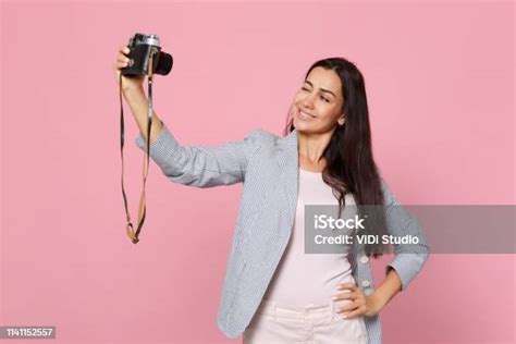 분홍색 파스텔 배경에 고립 된 레트로 빈티지 사진 카메라에 Selfie 샷을 하 고 줄무늬 재킷에 깜박이 젊은 여자의 초상화 사람들은 진심으로 감정 라이프 스타일 개념입니다