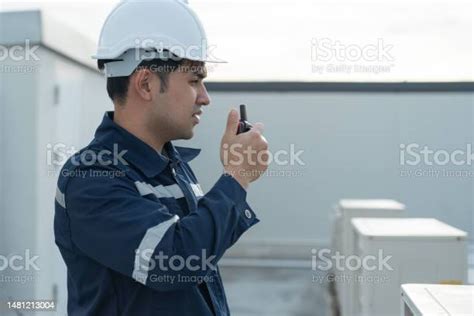 아시아 유지 보수 엔지니어는 공장 지붕에서 일합니다 계약자는 압축기 시스템을 검사하고 건설 중인 에어컨 시스템 설치를 계획합니다 기술 워키 토키 유지 보수 25 29세에