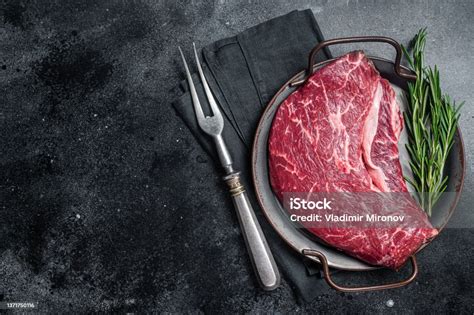 로즈마리가 있는 강철 트레이에 생톱 등심 쇠고기 고기 스테이크 검은 색 배경 맨 위 보기입니다 복사 공간 0명에 대한 스톡 사진