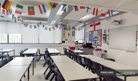 National Flags Hanging Above Tables In Classroom — High School Global