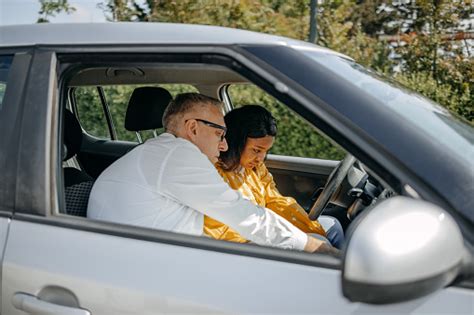 자동차의 다양한 기능을 설명하는 강사와 함께 운전 수업을 받는 젊은 여자 20 24세에 대한 스톡 사진 및 기타 이미지 20 24세 2명 50 54세 Istock
