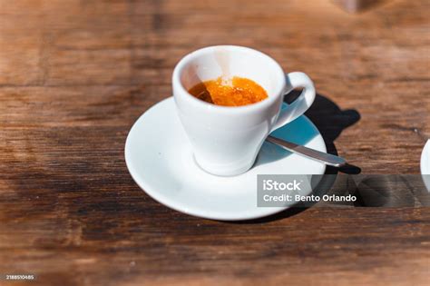 소박한 나무 테이블에 접시와 함께 화이트 컵에 담긴 따뜻한 에스프레소 샷 자연 채광 아래에서 완벽한 모닝 커피의 순간을 포착하여 영감을 찾는 카페 애호가와 커피 애호가에게