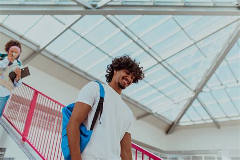 파란색 배낭을 메고 현대적인 아프리카 헤어스타일과 활짝 웃는 얼굴을 한 아프리카계 미국인 학생은 열정을 발산하고 야망 다양성 학습 및 개인적 성장에 대한 열정을 구현하는