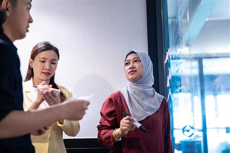 히잡의 선임 무슬림 사업가가 회의실에서 동료들에게 비즈니스 아이디어를 제시하고 계획을 제시합니다 모임에 대한 스톡 사진 및 기타