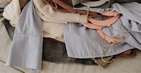 옷 더미 옆 소파에 앉아 있는 여자 사진 Unsplash의 정리 정돈 이미지