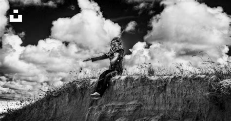 재킷과 바지를 입은 남자가 흐린 하늘 아래 잔디밭에서 점프하는 회색조 사진 사진 Unsplash의 무료 회색 이미지