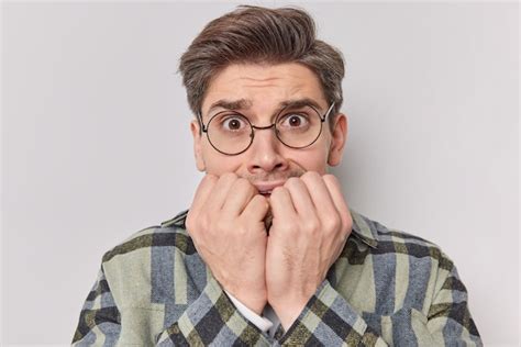 Free Photo Man Bites Finger Nails Looks With Nervous Wears Spectacles And Casual Clothes Poses