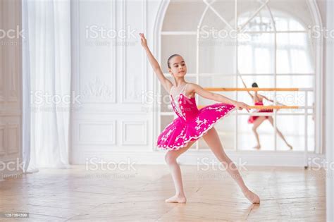 밝은 투투를 입은 작은 발레리나는 큰 조명 홀 한가운데서 뾰족한 지점에 서 있습니다 8 9 살에 대한 스톡 사진 및 기타 이미지