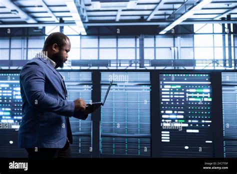 African American Man In Data Center Monitoring System Performance Identifying Bottlenecks And