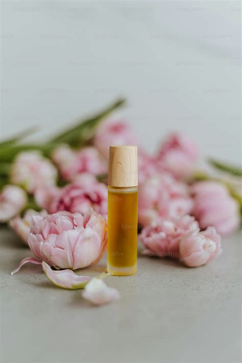꽃 한 무리 옆에 에센셜 오일 한 병 사진 Unsplash의 꽃 이미지