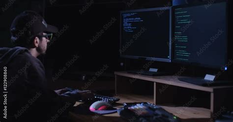 Cyber Terror Computer Hacker Sitting In A Dark Room In Front Of