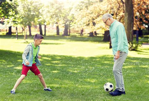 Premium Photo Old Man And Boy Playing Football At Summer Park