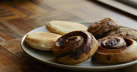 화분 옆 탁자 위에 놓인 쿠키 한 접시 사진 Unsplash의 시나몬 롤 이미지