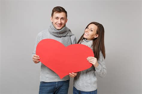 귀여운 젊은 회색 스웨터 스카프 함께 회색 벽 배경 스튜디오 초상화에 고립에서 여자 남자 커플 건강 한 라이프 스타일 아픈 아픈