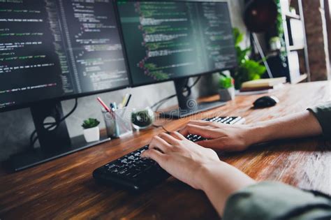 Young Female Programmer Working With Code On Dual Monitors In A Stylish