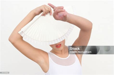 플라멩코 댄서가 하얀 팬으로 얼굴을 가린 채 하얀 배경에 입술과 팔을 들고 있는 모습을 볼 수 있습니다 플라멩코에 대한 스톡