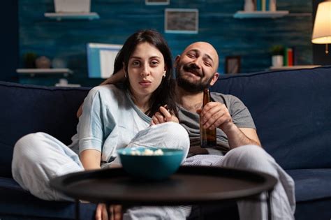 Casal Relaxado Sentado No Sofá Assistindo Filme Na Televisão Foto Premium