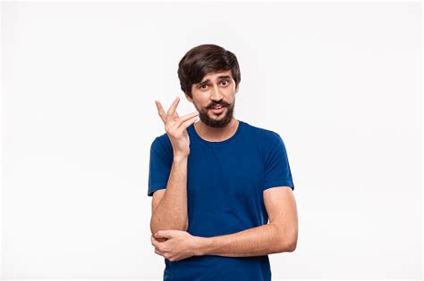 파란색 셔츠를 입은 사려 깊은 잘생긴 브루넷 남자는 한 손을 흰색 배경 위에 고립 된 얼굴에 가깝게 유지하는 좋은 아이디어를 반영합니다 감정에 대한 스톡 사진 및 기타