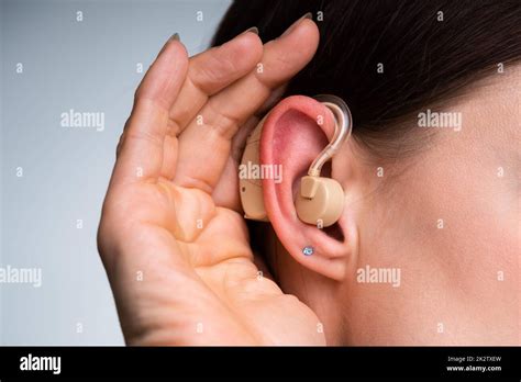 Woman Inserting Hearing Aid In Her Ear Stock Photo Alamy