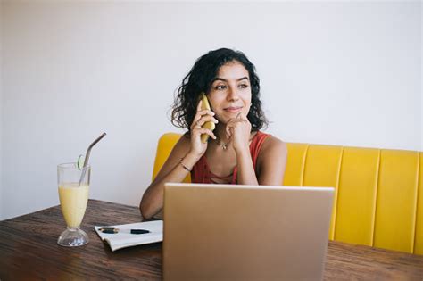 동료에게 전화하고 시작 프로젝트 세부 사항에 대해 논의하기 위해 스마트 폰 응용 프로그램을 사용하는 중동 프리랜서 휴대 전화를 통해 이야기하기위한 노트북 및 플래너 메모장