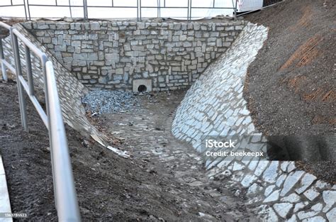 화강암 돌로 포장된 하수도 배수구와 제방은 고속도로에서 도랑으로 빗물을 배수하여 배수 그리드가있는 파이프를 통해 물이 하수구로 느려지는 유지 저수지로 흘러 들어갑니다