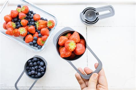 더 많은 열매 위에 딸기로 가득 찬 측정 컵을 들고있는 여성 손 건강한 생활방식에 대한 스톡 사진 및 기타 이미지 건강한 생활방식 건강한 식생활 계량컵 Istock