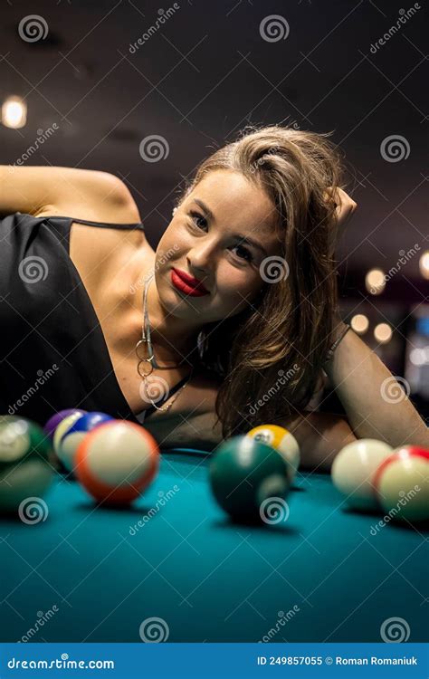 Female Pool Player Wear Black Dress Lying On Billiard Table Stock Image