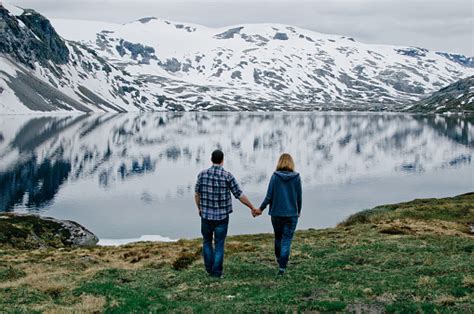 한 쌍의 연인은 북부 노르웨이에서 손을 잡고 걷는다 멋진 풍경 여름의 대자연의 아름다움 돌 호수와 산 여행 관광 로맨틱 남자와 여자 관광 라이프 스타일 2명에 대한 스톡