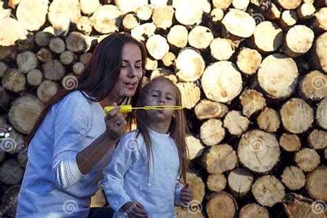 Mamá Y Su Hija Soplan Burbujas Al Fondo De La Leña Mujer Feliz Con