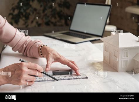Close Up Of Unrecognizable Female Architectural Drafter In Ring Using Ruler While Working With