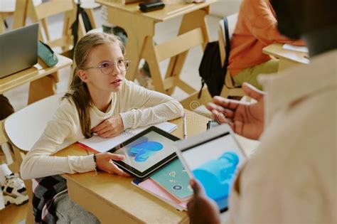 Young Girl Engaging In Classroom Learning With Tablet Stock Image