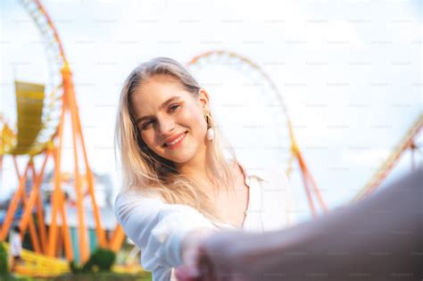 놀이 공원에서 남성 손을 잡고 있는 여성 미소 짓는 얼굴에 초점 커플 데이트 개념 사진 Unsplash의 공생 이미지