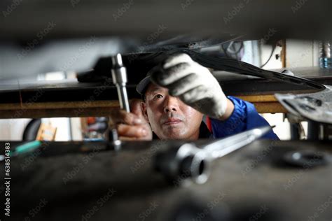 동네 카센터에서 리프트에 올려진 자동차 하체를 점검하는 엔지니어의 클로즈업 Photos Adobe Stock
