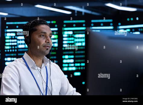 Developer Using Computer To Troubleshoot Hardware And Software Errors In Server Farm Man In