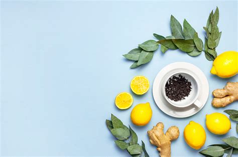 창조적 인 음식 개념 신선한 생강 뿌리 내부 양조와 컵 차 레몬 유칼립투스 잎은 파란색 배경에 플랫 레이 상단 뷰 복사
