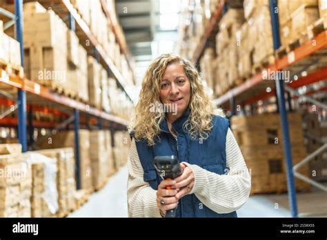 Frontal View Of A Caucasian Blonde Woman Scanning Packages In A Distribution Warehouse Stock