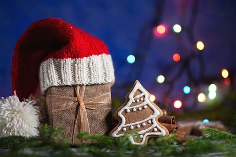 크리스마스와 새해 선물 상자 크리스마스 트리 가지와 화환 파란색 배경에 산타 모자에 크래프트 종이에 포장 크리스마스 트리 모양의 쿠키 12월에 대한 스톡 사진 및 기타