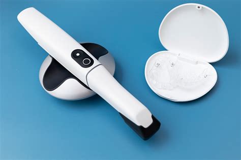 흰색 3d 구강 내 치과 치아 스캐너와 치아 야간 경비원은 파란색 배경에 상자에 있습니다 치과 구강 관리 치아 스캔 장치 치과 및 건강 관리 개념 평면 의료용 스캐너에 대한