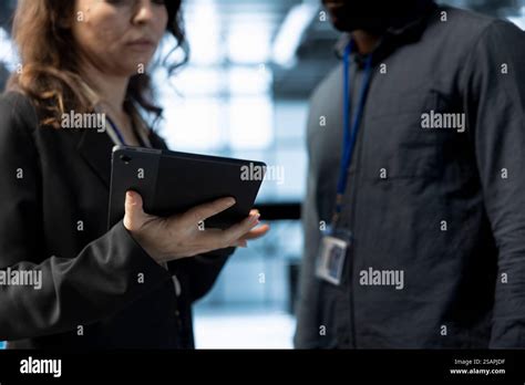 Teamworking Colleagues In Data Center Using Tablet Analyzing Metrics Optimizing Storage