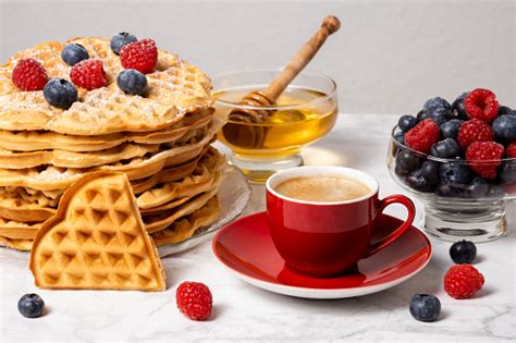 벨기에 와플 딸기 꿀 빨간 커피 한 잔 대리석 테이블에서 맛있는 여름 아침 식사 하트 모양의 와플과 라즈베리와 블루베리를 토핑으로 얹은 요리 0명에 대한 스톡 사진 및 기타