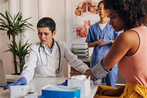 간호사가 의료 차트에서 메모를하는 동안 여성 의사는 환자의 혈압을 검사하고 있습니다 3 명에 대한 스톡 사진 및 기타 이미지