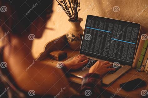 Back View Of Caucasian Female Programmer Siting At Desk Using Laptop With Coding On Screen
