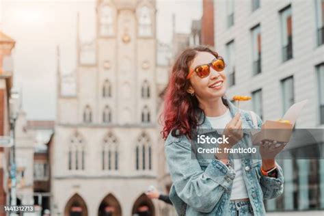 테이크 아웃 종이 상자에 독일 뮌스터시의 거리에서 반죽이나 감자 튀김에 새우와 함께 패스트 푸드를 간식으로 먹는 쾌활한 행복한 소녀 30 34세에 대한 스톡 사진 및 기타