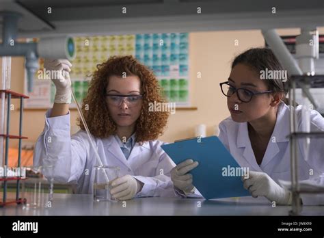 Female College Babes Practicing Chemistry Experiment At Desk In Lab Stock Photo Alamy