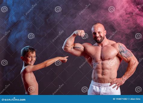 Powerful Muscular Man Shirtless Posing With His Son In The Studio With