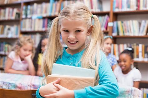 Premium Photo Cute Pupils Looking At Camera In Library